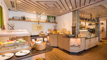Uma área de buffet com diversos tipos de comida e um espaço para café.