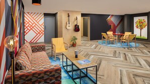 Uma sala de estar moderna com sofá, mesa de centro e área de jantar com cadeiras e mesa.