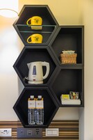 Uma estante hexagonal com uma chaleira, duas garrafas de água e uma cesta.