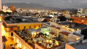 Terraço no telhado com área de estar ao ar livre e vista para a cidade.