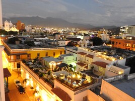 Terraço no telhado com área de estar ao ar livre e vista para a cidade.