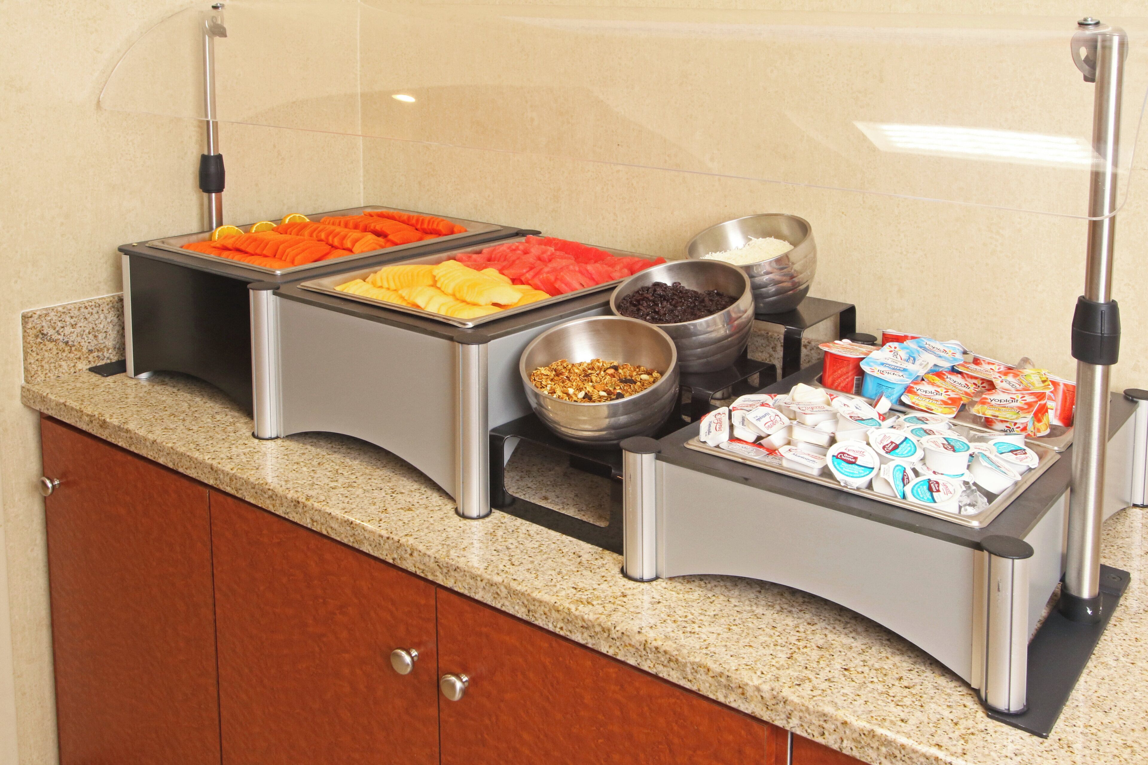 Disposição de buffet com diversos alimentos e recipientes.