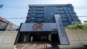 Um edifício moderno com um logotipo 'R' bem visível na entrada.