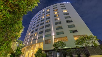 Um hotel com vários andares e design moderno, com um letreiro 'ANYA' bem visível no topo.