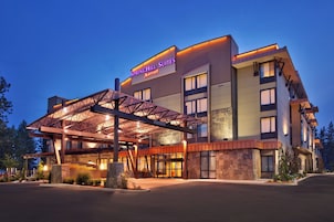 Um hotel Springhill Suites Marriott com design moderno, apresentando uma entrada coberta e uma placa bem visível.