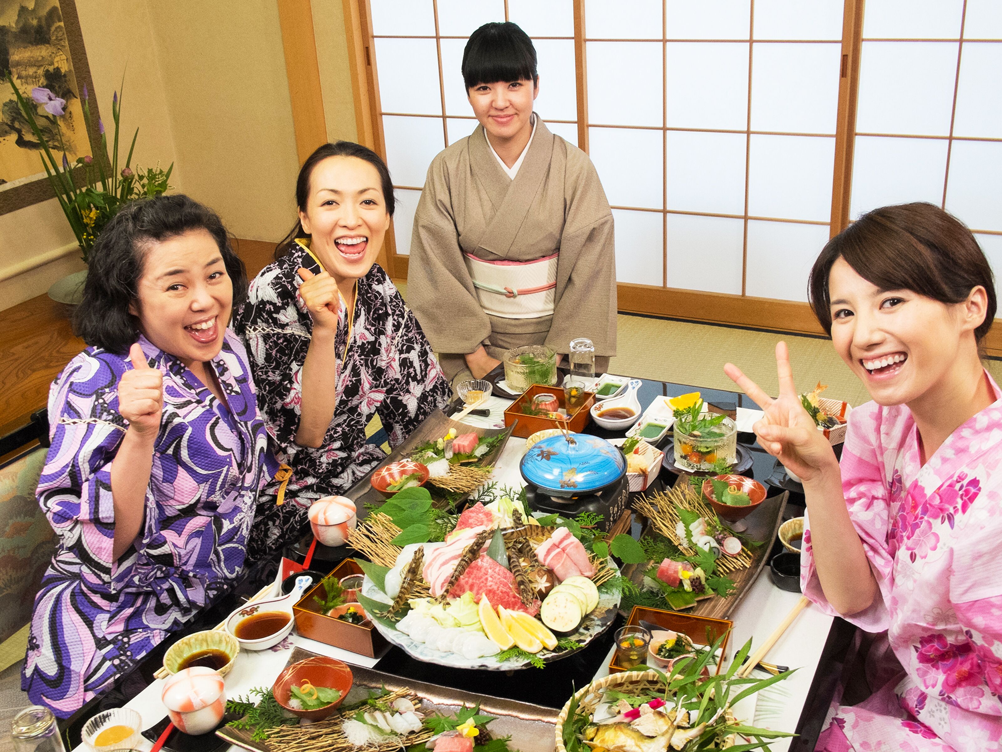Uma refeição tradicional japonesa com diversos pratos e piso de esteiras de tatame.