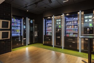 Interior moderno com máquinas de venda automáticas com a inscrição 'PUSH Vision' e piso de madeira.