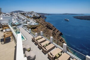 Terraço no telhado com área de estar ao ar livre e vista para o mar.