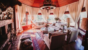 Um quarto aconchegante com lareira, sofá, mesa de centro e lustre.
