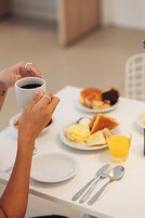 Uma mesa com café da manhã, incluindo pratos de comida, uma xícara de café e um copo de suco de laranja.