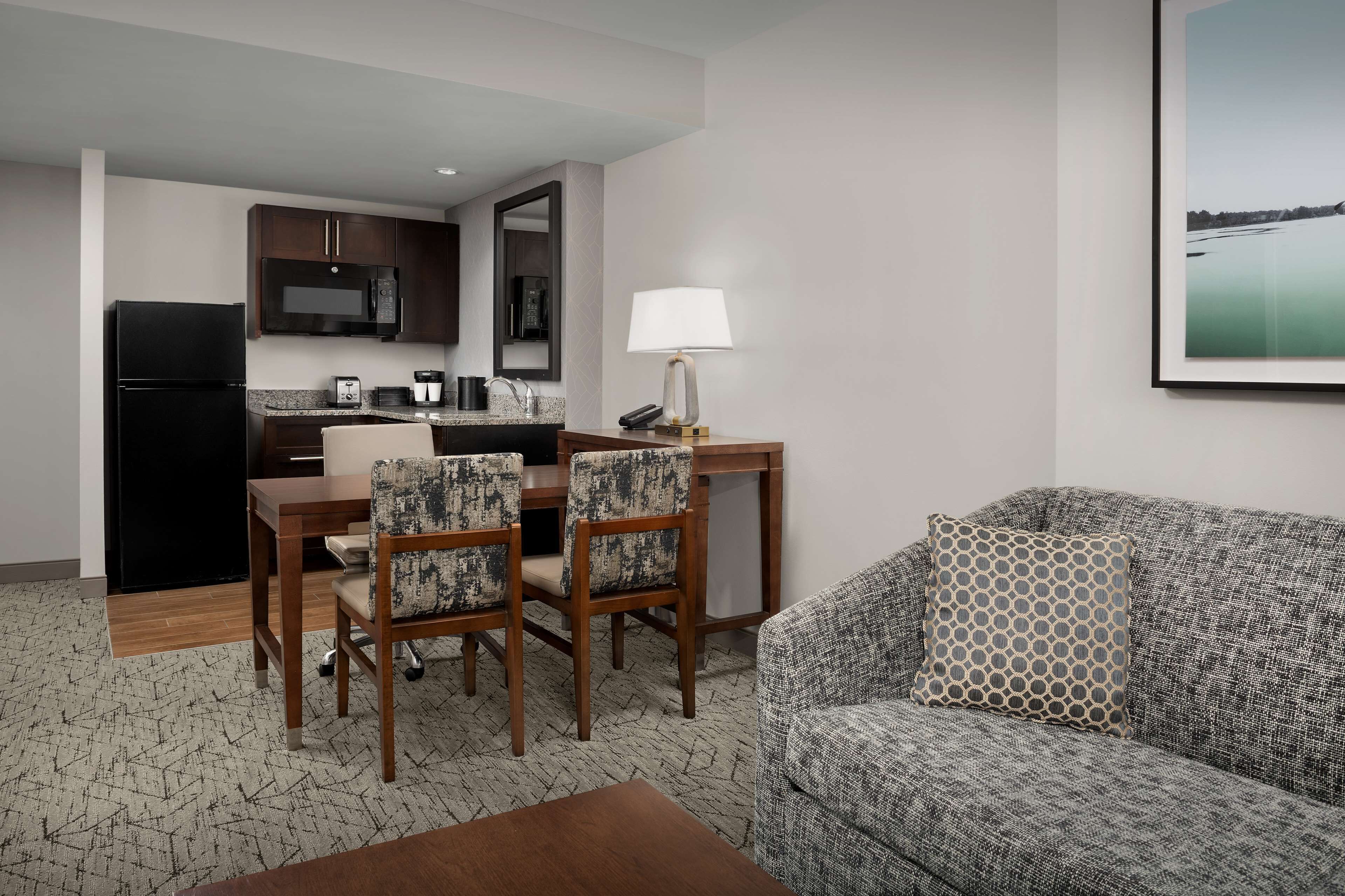 Quarto de hotel compacto com cozinha compacta, área de refeições e sofá.