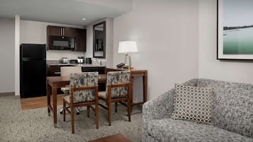 Quarto de hotel compacto com cozinha compacta, área de refeições e sofá.