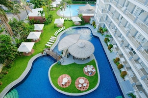 Um hotel com piscina, áreas de estar ao ar livre e uma ponte que liga diferentes partes da propriedade.