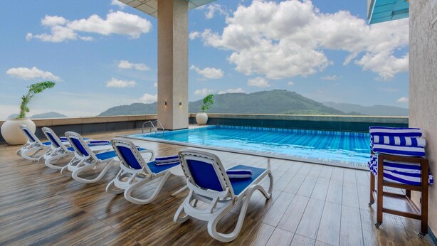 Área de piscina com espreguiçadeiras e vista para as montanhas.