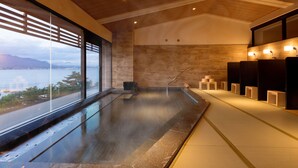 Casa de banho moderna com uma janela ampla, piso aquecido e vista para a água.