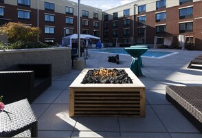 Um terraço no terraço com lareira, área de estar externa e piscina.
