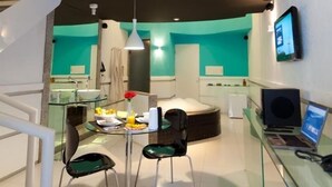 Um interior moderno com uma área de jantar, uma escada e uma televisão.