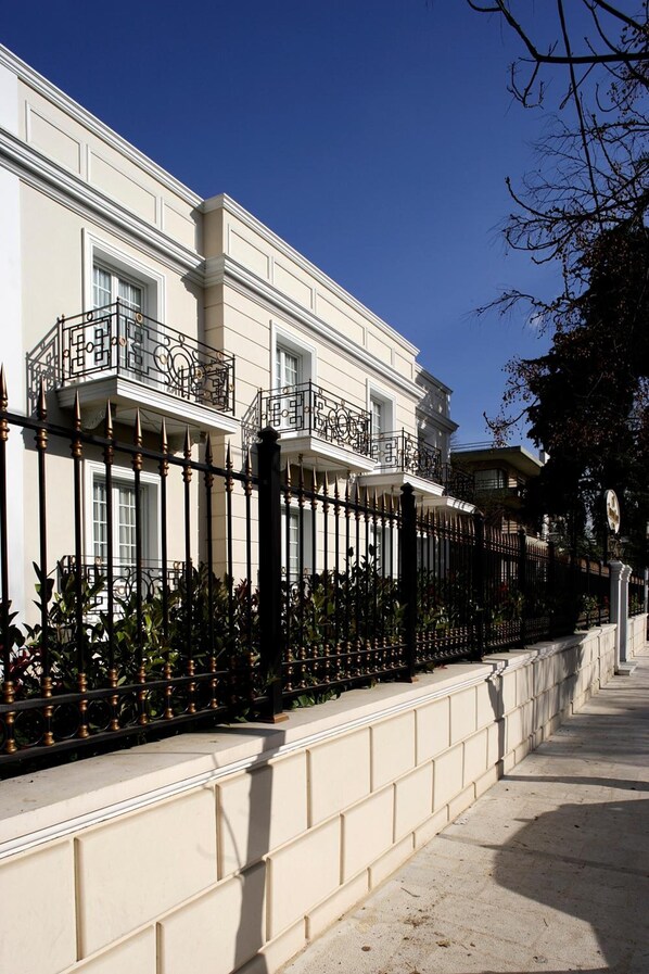 Um edifício clássico com fachada simétrica, entrada central e grade decorativa de ferro.
