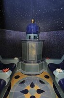 Um quarto com teto que remete a uma noite estrelada, uma estrutura central em forma de cúpula azul e dourada, e piso com padrão.