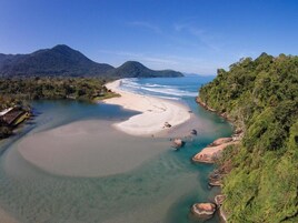 Na praia, areia branca, guarda-sóis, toalhas de praia 