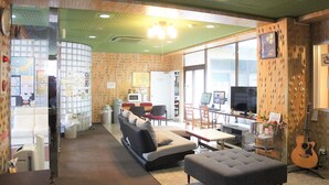 Um interior moderno com sofá, um banquinho e uma área de jantar com cadeiras e mesa.