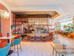 Uma área de bar com balcão, banquetes e prateleiras repletas de garrafas.