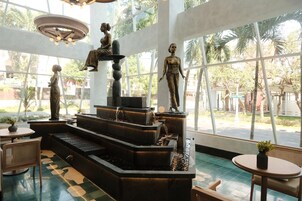 Um interior moderno com uma cascata escalonada, áreas de estar e amplas janelas com vista para o exterior.