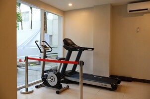 Uma academia doméstica com esteira, bicicleta ergométrica e elíptico.