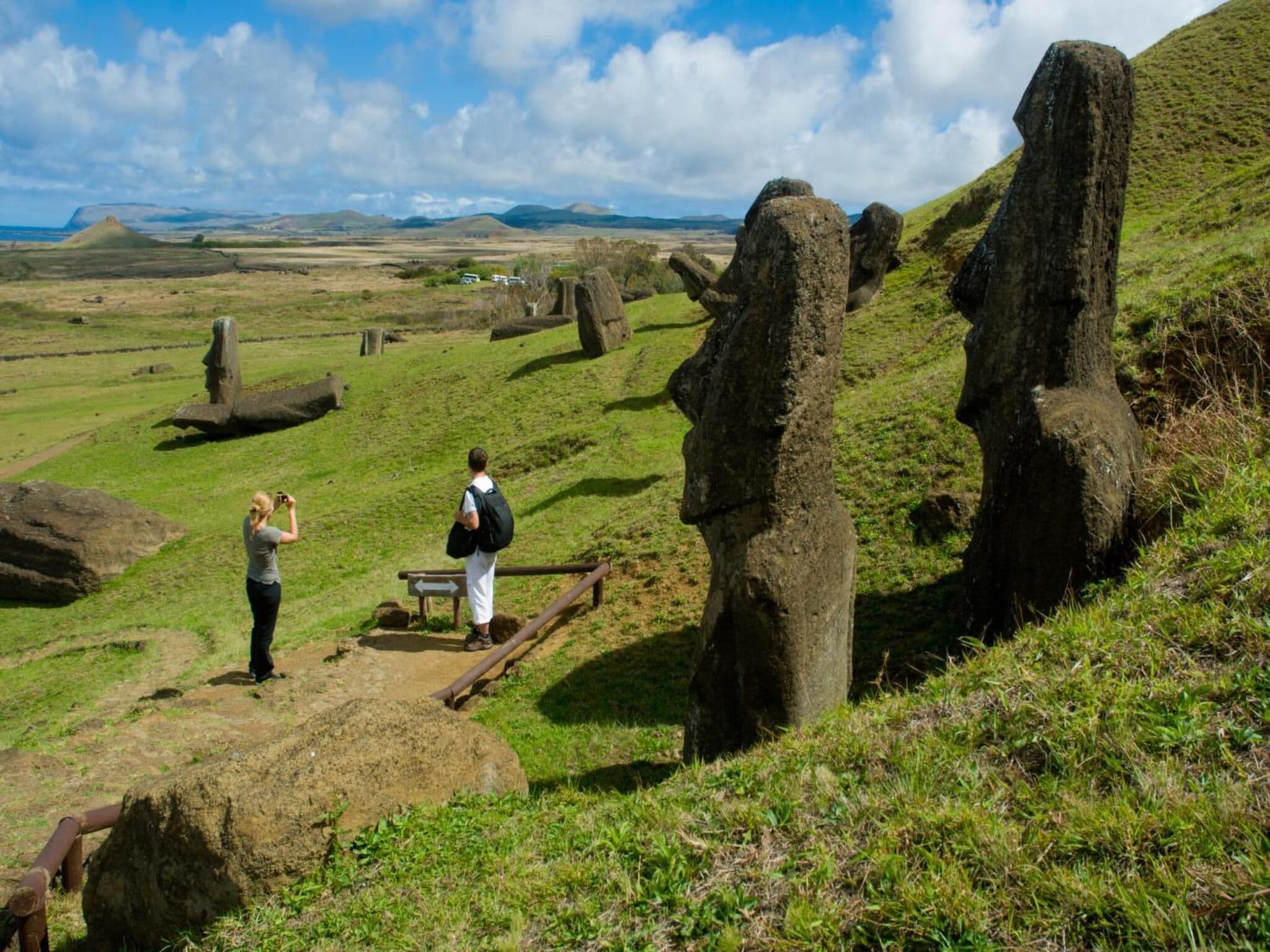 Paisagem com grandes pedras erguidas e um campo gramado.