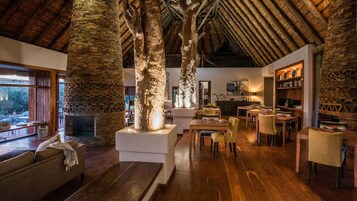 Um interior rústico com paredes de pedra aparente, vigas de madeira e uma área de estar acolhedora com lareira.