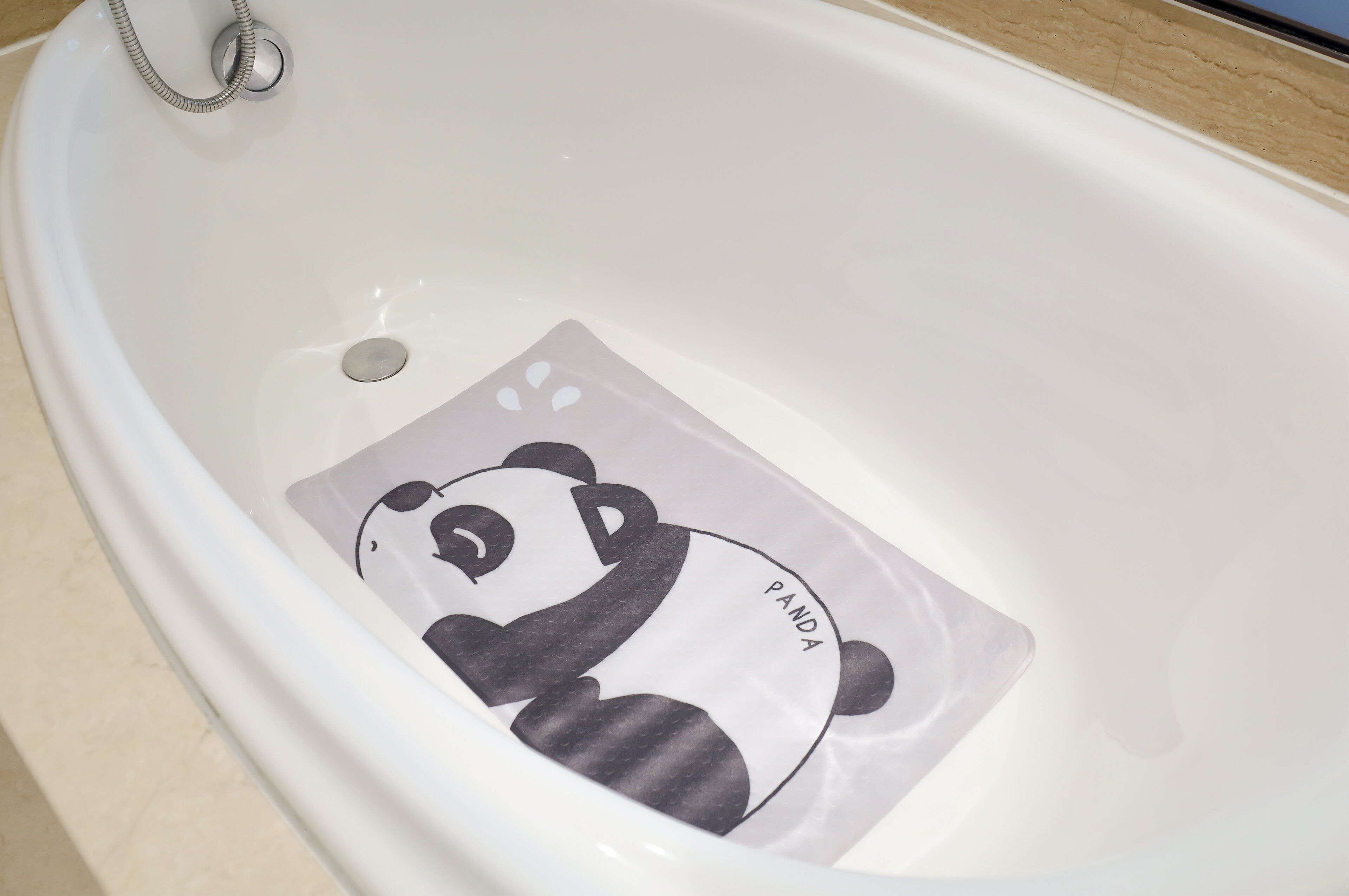 Uma banheira branca com um tapete de tema panda.