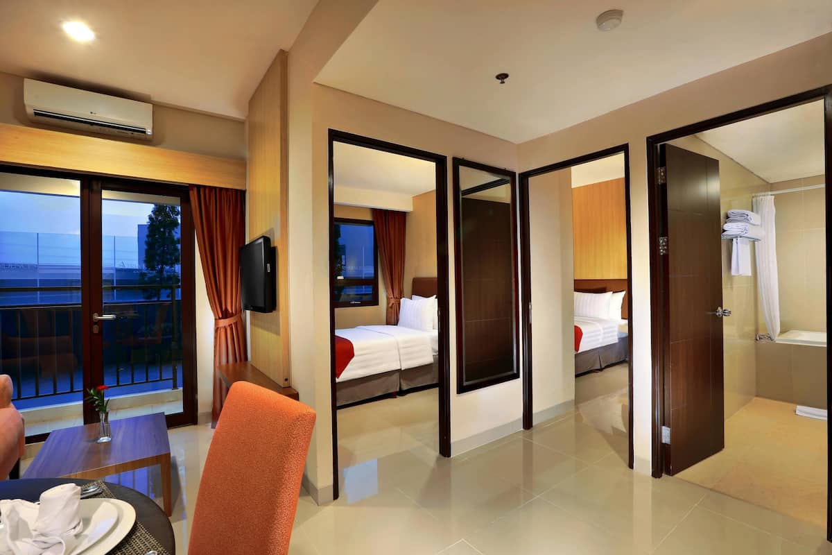 Quarto de hotel com varanda, uma cama, uma escrivaninha e casa de banho.