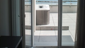 Quarto com vista para o mar através de grandes portas de vidro.