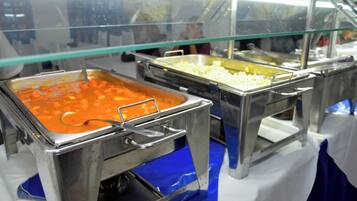 Uma mesa de buffet organizada com vários pontos de serviço, cada um com diferentes tipos de comida.