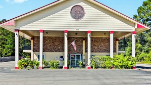Um edifício com fachada de tijolos, entrada coberta e uma bandeira americana.