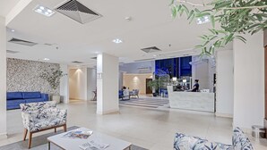 Um hall amplo com balcão de recepção, área de estar e design de interiores moderno.
