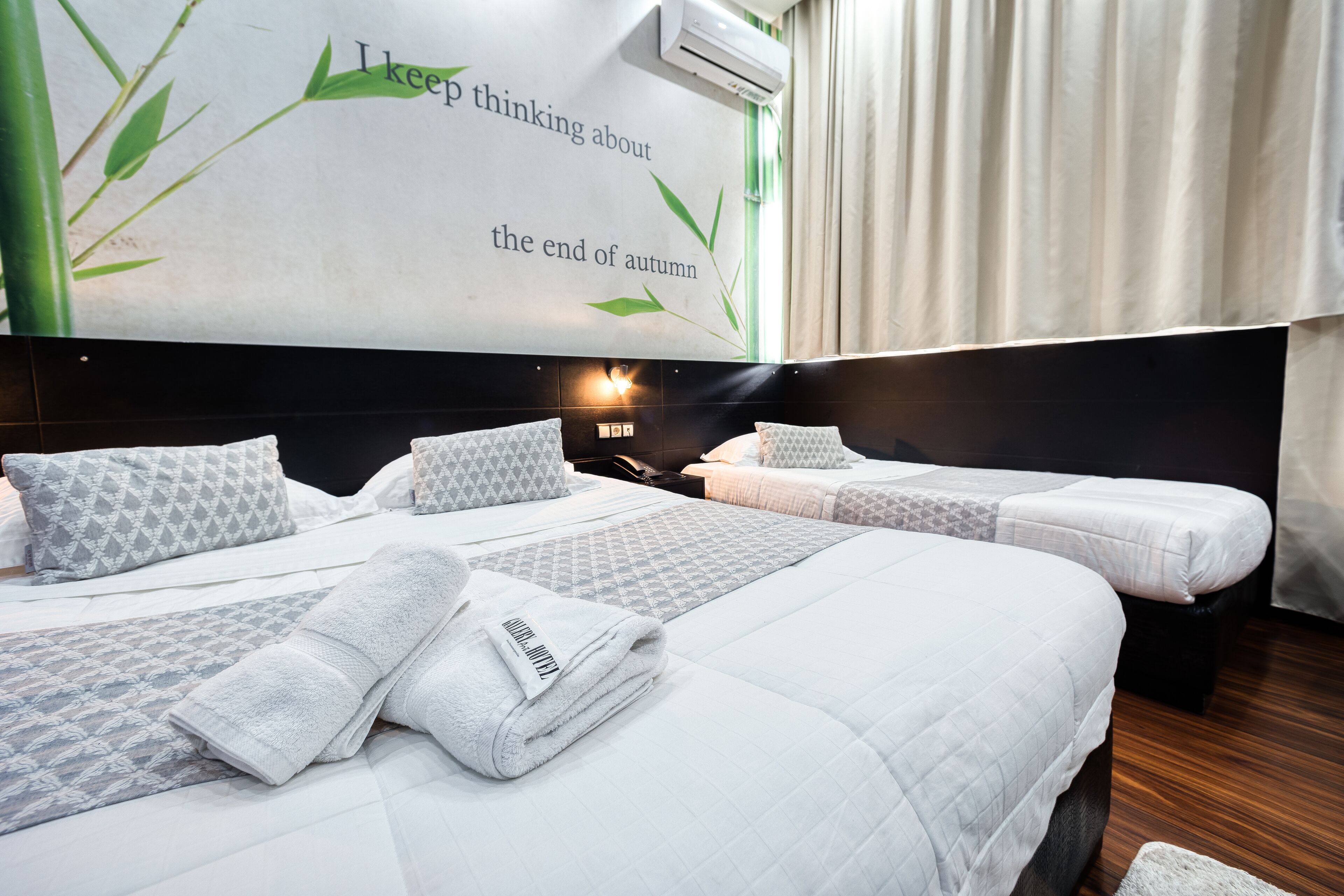 Quarto de hotel com duas camas, um mural grande na parede e um design moderno.