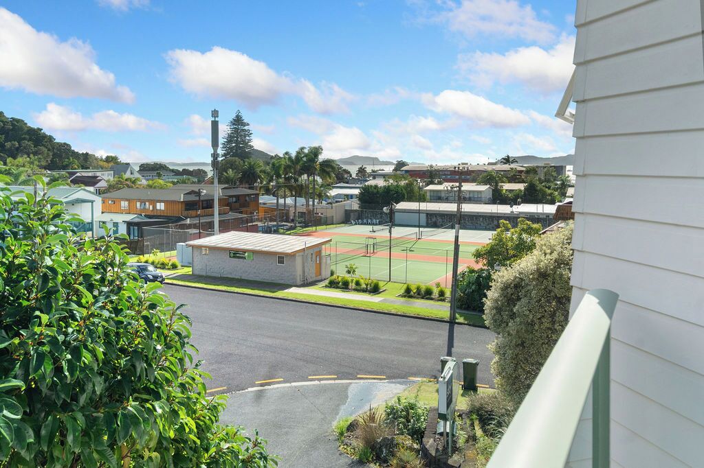 Área residencial com campo de esportes, casas e vegetação.