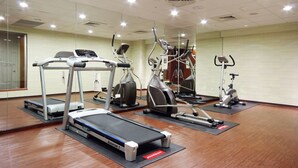 Uma academia com esteiras, elípticos e bicicletas ergométricas.