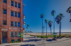 Um edifício de tijolos com uma placa indicando 'Breeze Suites' e uma praia ao fundo.