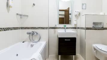 Uma casa de banho moderna com banheira, lavatório, sanita e chuveiro.