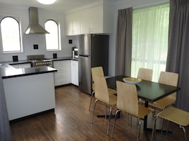 Um frigorífico/congelador grande, um micro-ondas, uma placa de cozinha