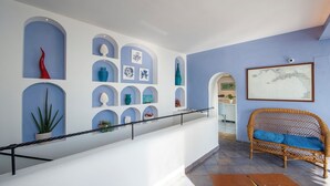 Um interior moderno com escada, paredes azuis e sofá de vime.