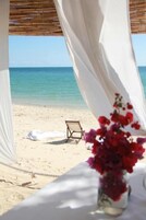 Praia particular, areia branca, espreguiçadeiras, guarda-sóis 