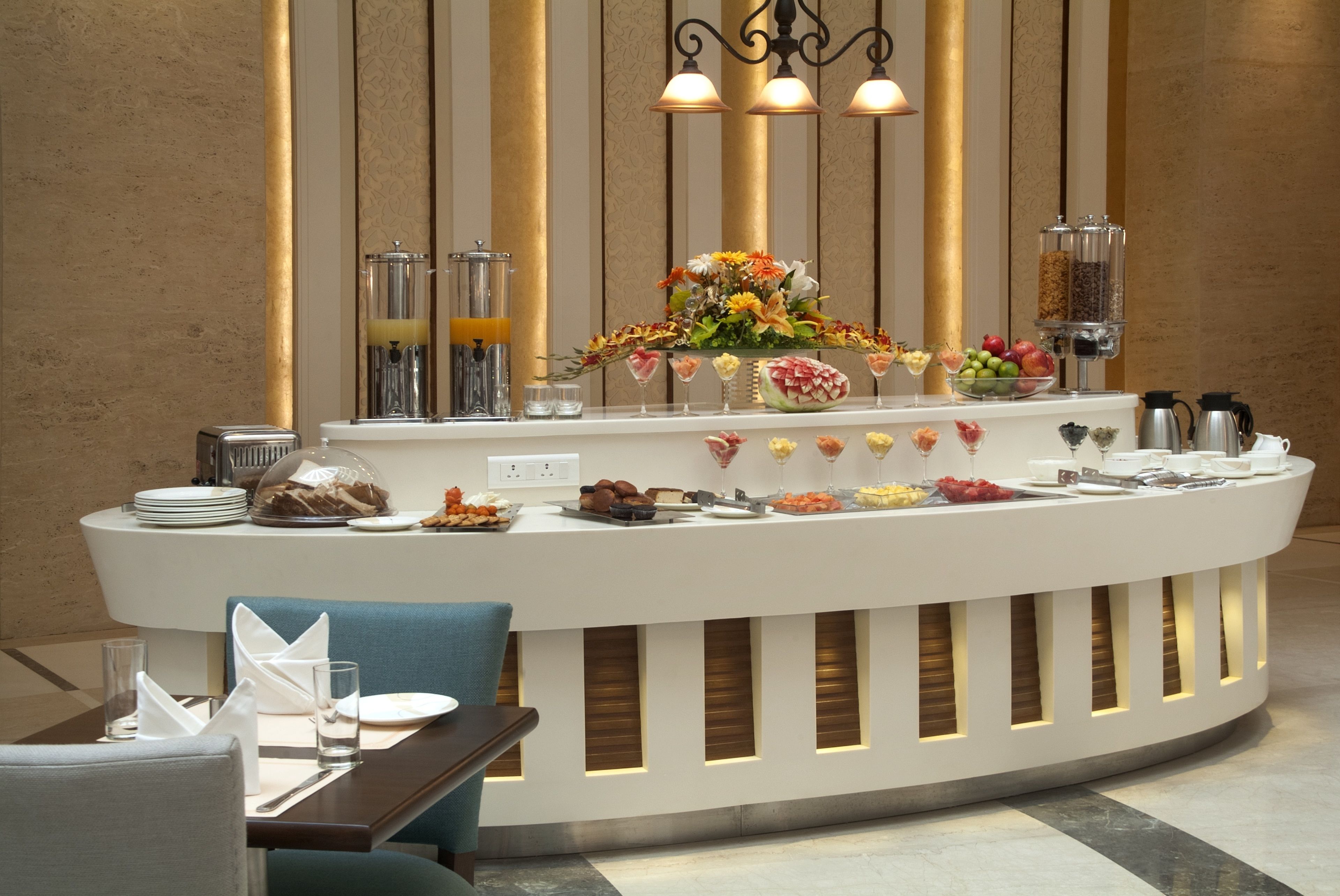 Um buffet de café da manhã com diversos alimentos e um arranjo floral.