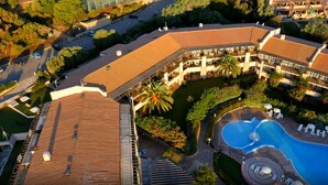 Resort com vários edifícios, piscina e jardins bem cuidados.