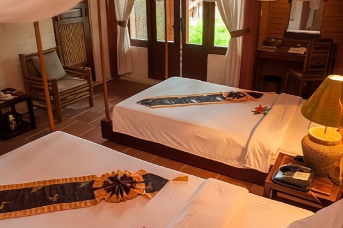Quarto de hotel com duas camas, uma escrivaninha e uma cadeira.