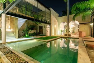 Um edifício moderno com piscina, área de estar ao ar livre e escadaria para um andar superior.