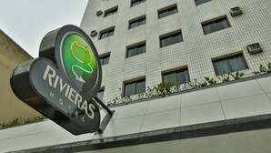 Placa de hotel com um logotipo verde e o nome 'RIVIERAS HOTEL'.