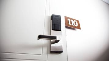 Uma porta com placa numérica '110' e uma maçaneta moderna.
